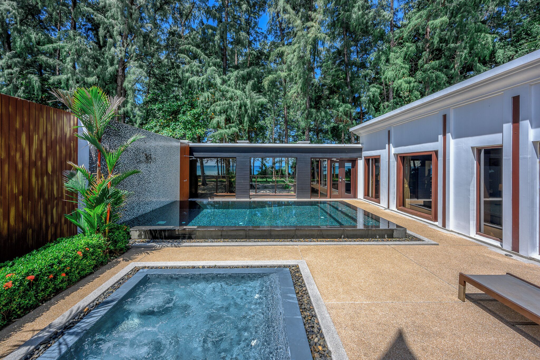 Uma casa moderna com piscina, banheira de hidromassagem e cerca de madeira.