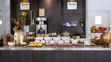 Buffet com diversos alimentos e uma estação de café.