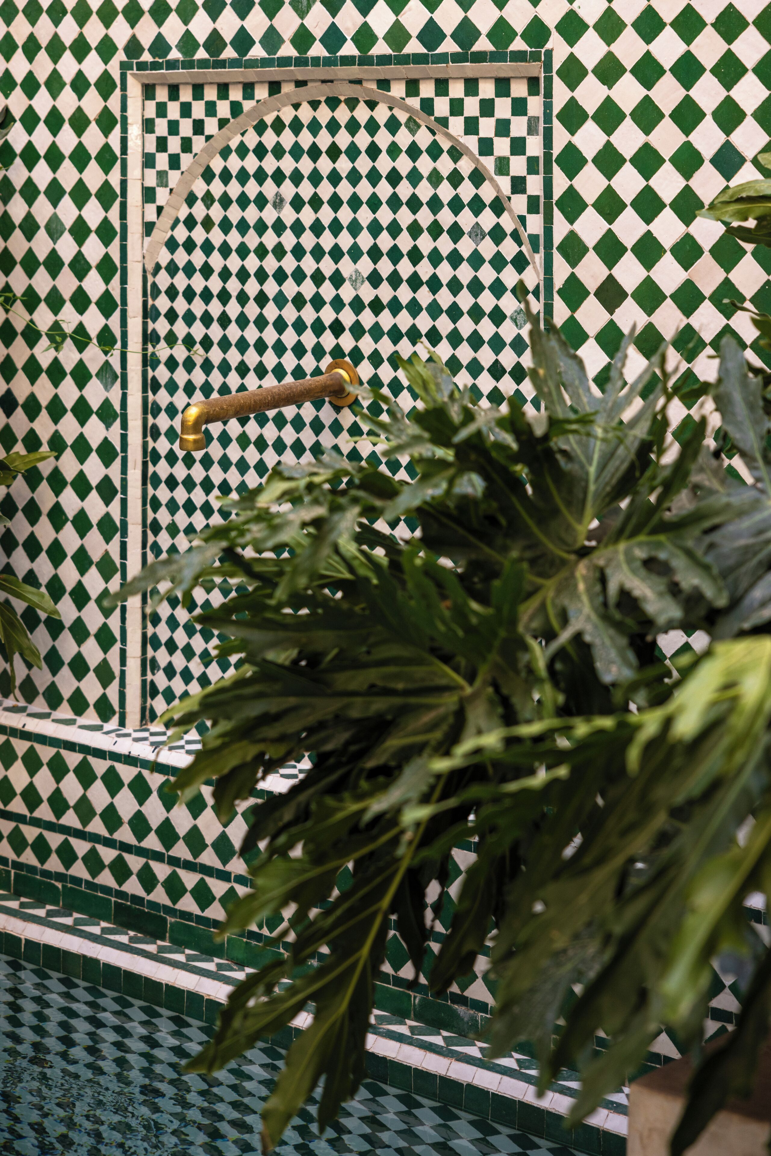 Parede de azulejos quadriculada com puxador de madeira.