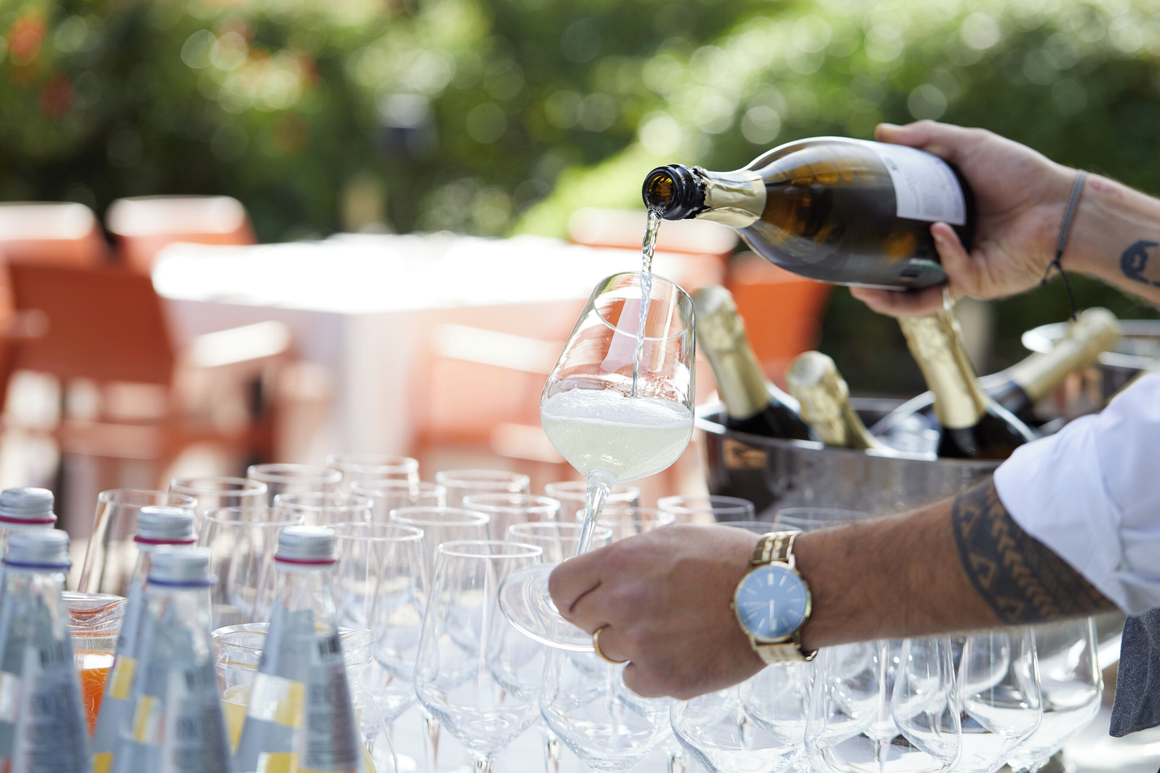 Alguém servindo vinho num copo a partir de uma garrafa.