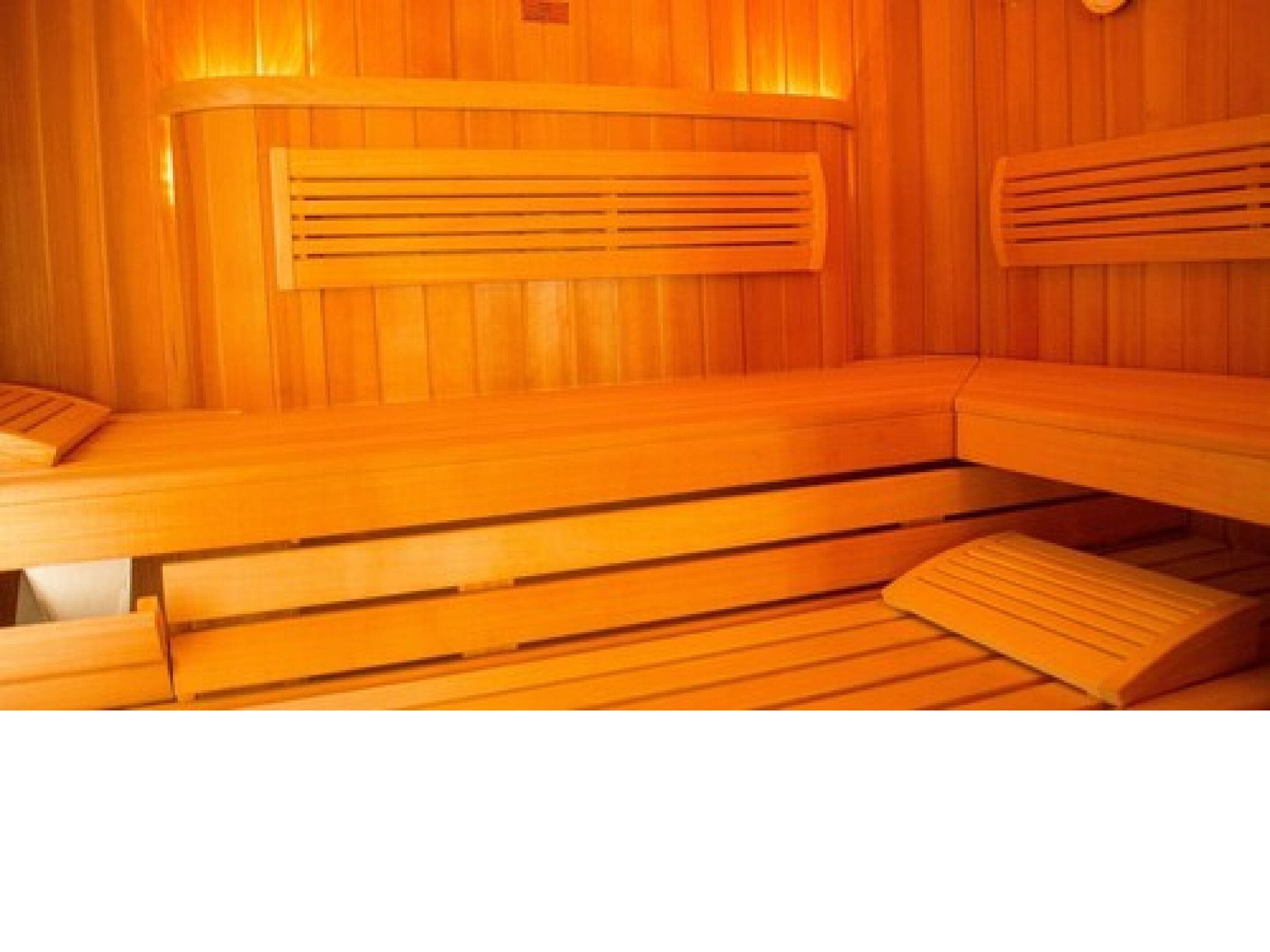 Uma sauna de madeira com bancos e um assento de banco.