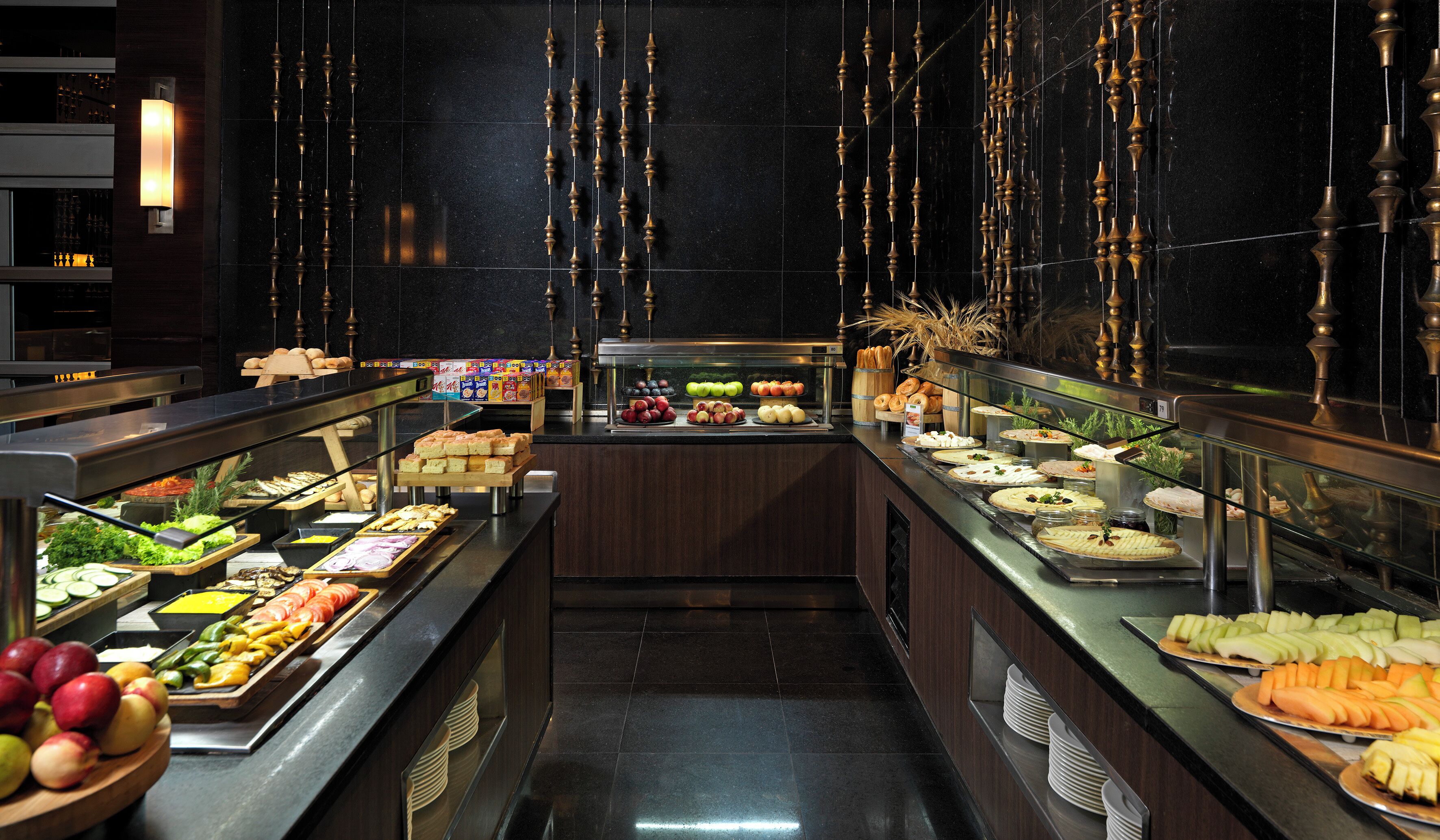 Buffet com diversos alimentos e uma seleção de pães.