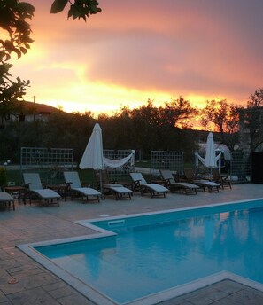 Piscina externa sazonal, funciona das 10h às 20h, guarda-sóis