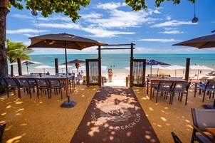 Na praia, espreguiçadeiras, guarda-sóis 