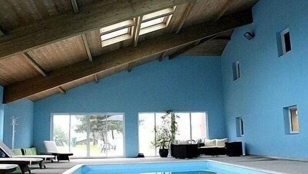Quarto com piscina, janelas amplas e parede azul.