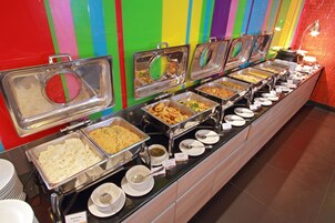 Buffet com diversos alimentos e utensílios de servir.