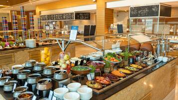Buffet com diversas opções de comida, incluindo frutas, legumes e pratos prontos.