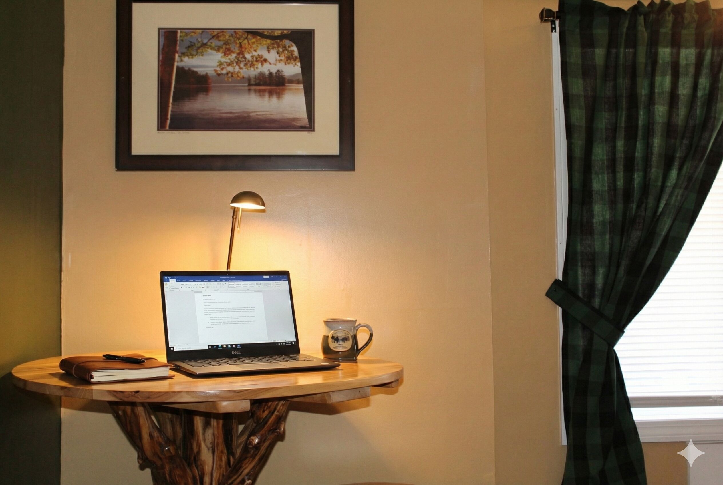 Um laptop sobre uma mesa de madeira, com uma lâmpada, uma caneca e um caderno.