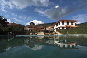 Um edifício grande com piscina na frente.