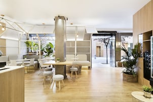Um interior moderno com piso de madeira, móveis brancos e plantas em vasos.