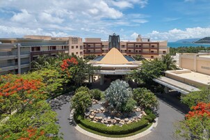 Hotel com átrio central, vários andares e vista para o mar.