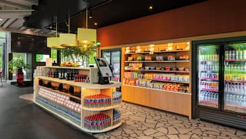 Uma área comercial moderna com resfriador de vinhos, prateleiras para lanches e um dispensador de bebidas.