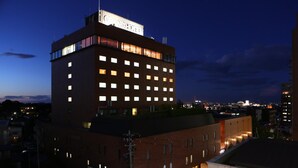 Um hotel com vários andares e um letreiro chamativo no topo.