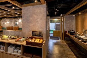 Uma área de café da manhã moderna com um balcão exibindo diversos alimentos e um micro-ondas.