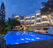 Um hotel com piscina, área de estar externa e escadaria que dá acesso aos andares superiores.