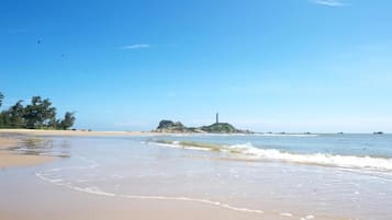 Uma praia privada, espreguiçadeiras, guarda-sóis de praia