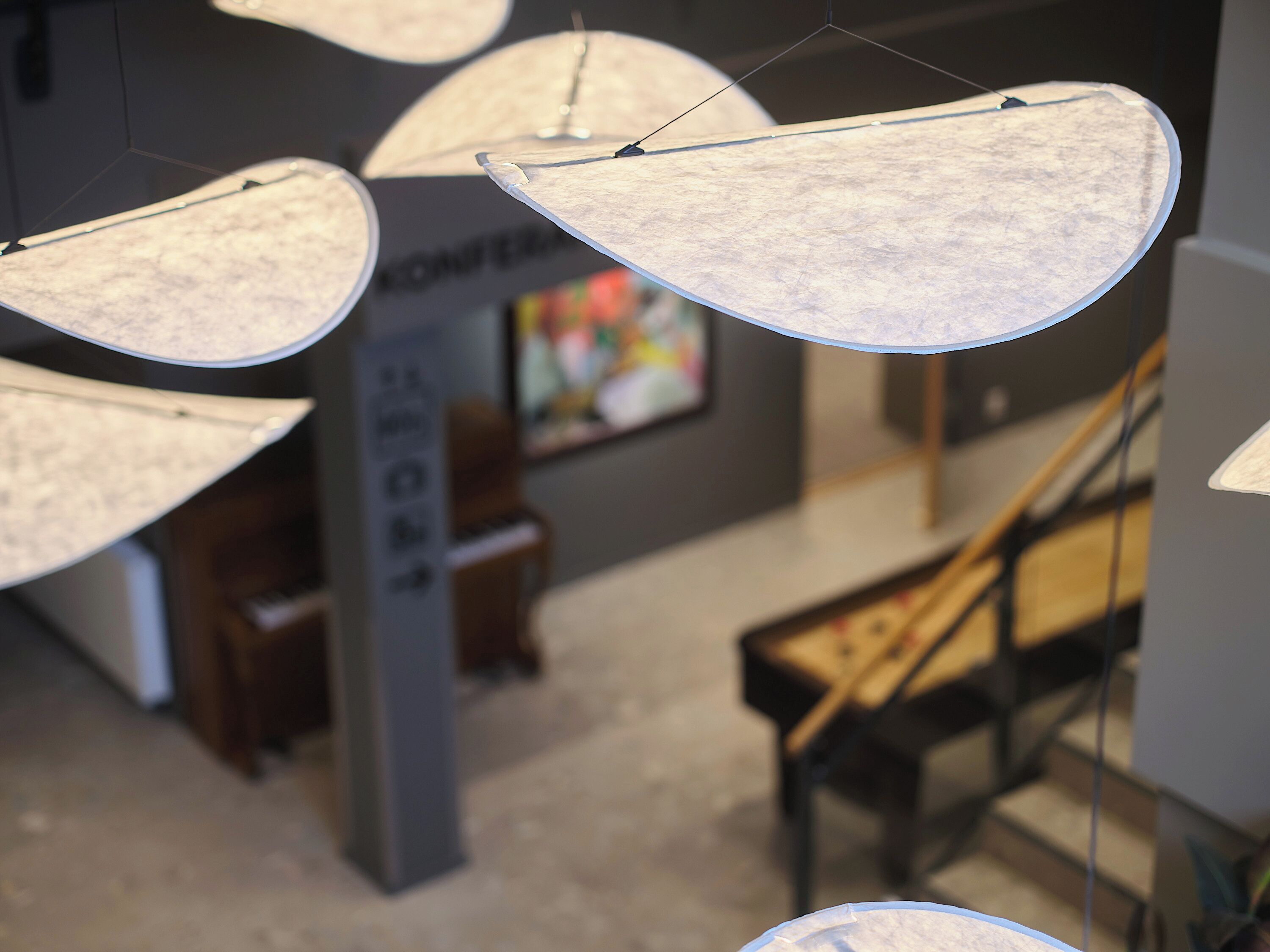 Um interior moderno com luminárias pendentes, uma escada e um piano.
