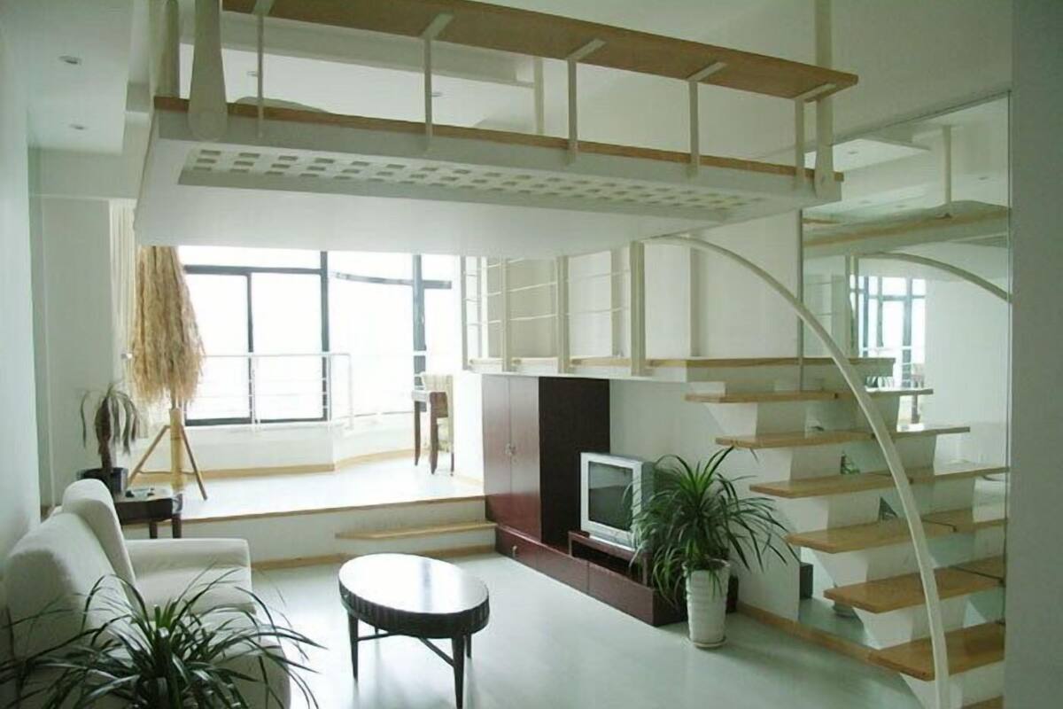 Uma sala de estar moderna com lareira, televisão e escada.
