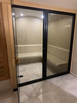 Quarto com porta de vidro deslizante que dá para um banheiro com paredes revestidas e banheira.