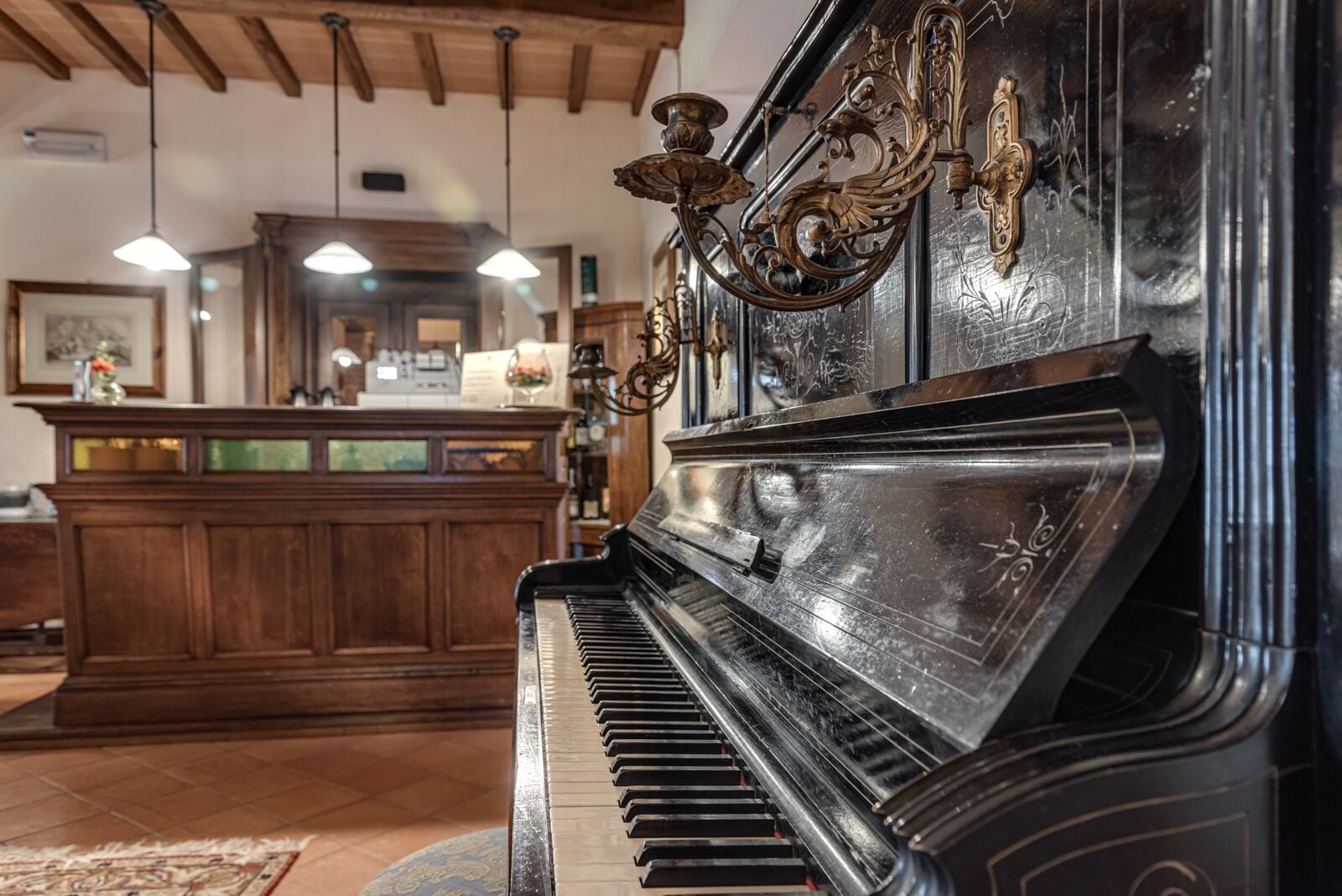 Um piano de cauda em um ambiente bem iluminado, com lambris de madeira e decoração na parede.
