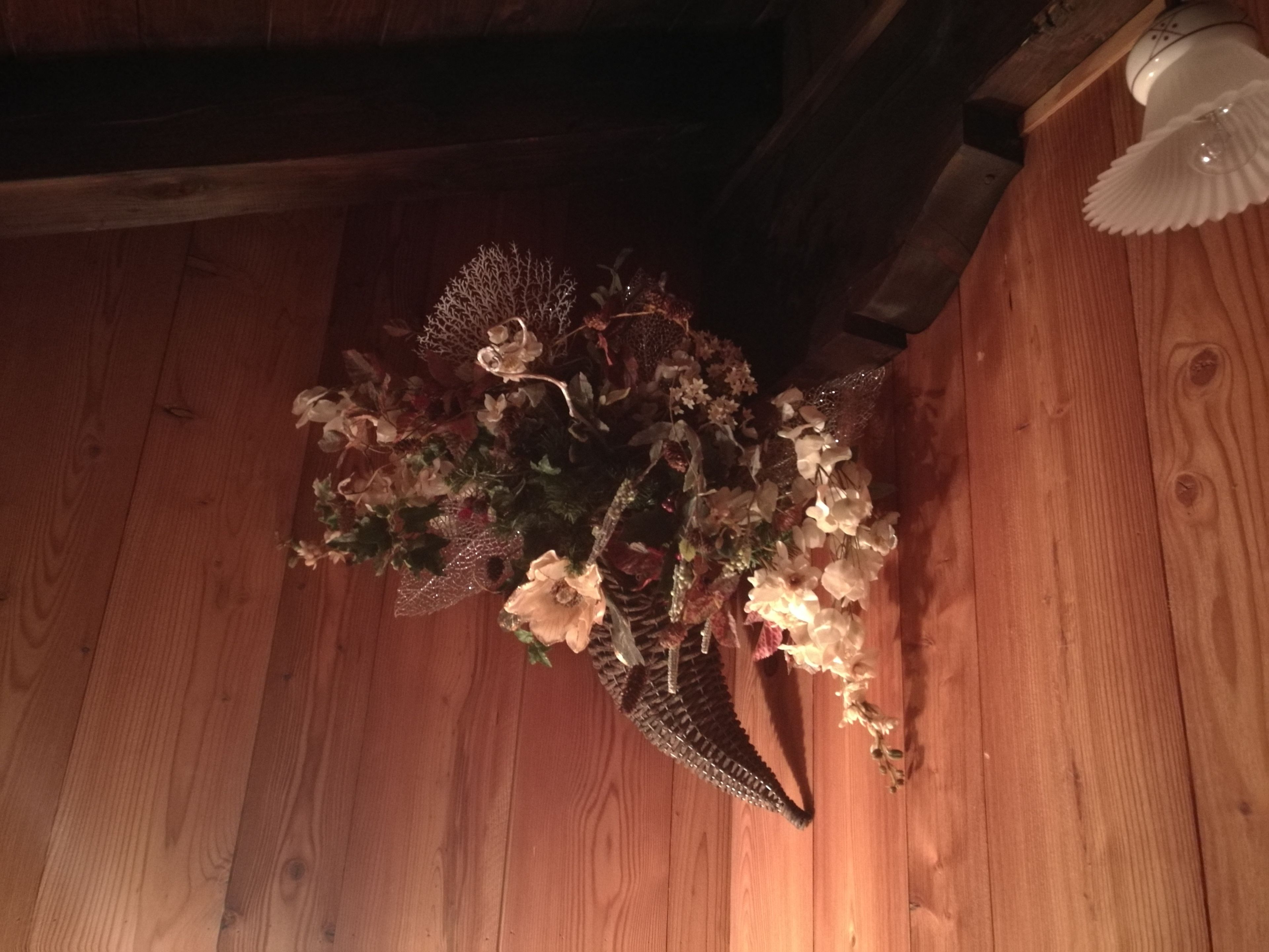 Piso de madeira com um arranjo decorativo de flores e um objeto de vidro.