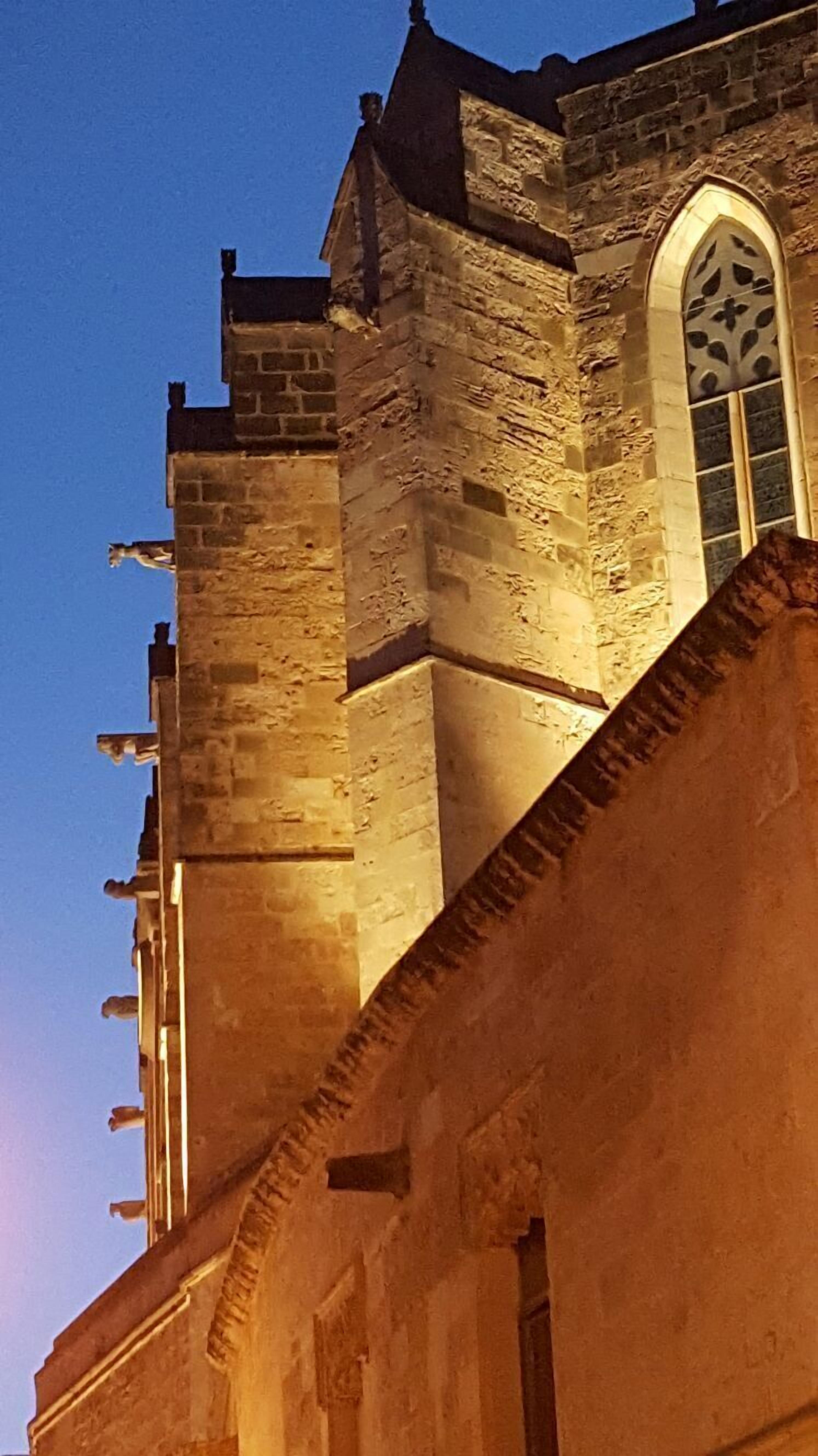Um edifício de pedra com uma grande janela em arco e várias janelas menores.