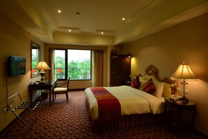 Quarto Deluxe, 1 cama king-size | Edredões de penas, camas de colchão pillowtop, minibar 