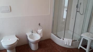 Casa de banho com sanita, bidé e chuveiro.