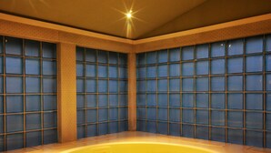 Uma banheira de hidromassagem com uma parede revestida de azulejos ao fundo.