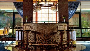 Um lobby com área de bar, assentos e vista para o exterior.
