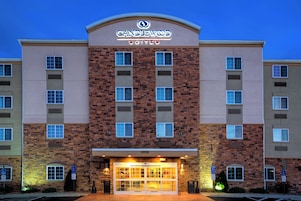 Um hotel com fachada de tijolos, várias janelas e uma placa indicando ser um Candlewood Suites.