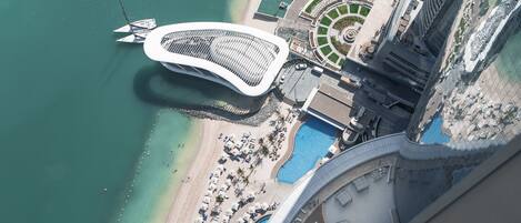 Um hotel moderno com design curvo único, área de piscina e localização à beira-mar.