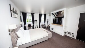 Quarto de hotel moderno com uma cama grande, uma mesa e uma cadeira.