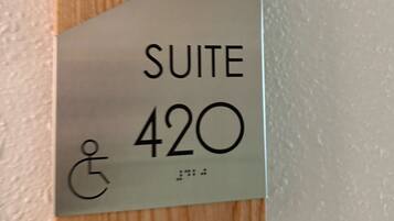 Placa com a inscrição 'Suite 420' e símbolo de acessibilidade para cadeirantes.