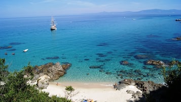 Uma praia privada, espreguiçadeiras, guarda-sóis de praia