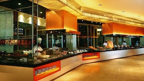 Disposição de buffet com um balcão longo, vitrines de vidro e chão ladrilhado.