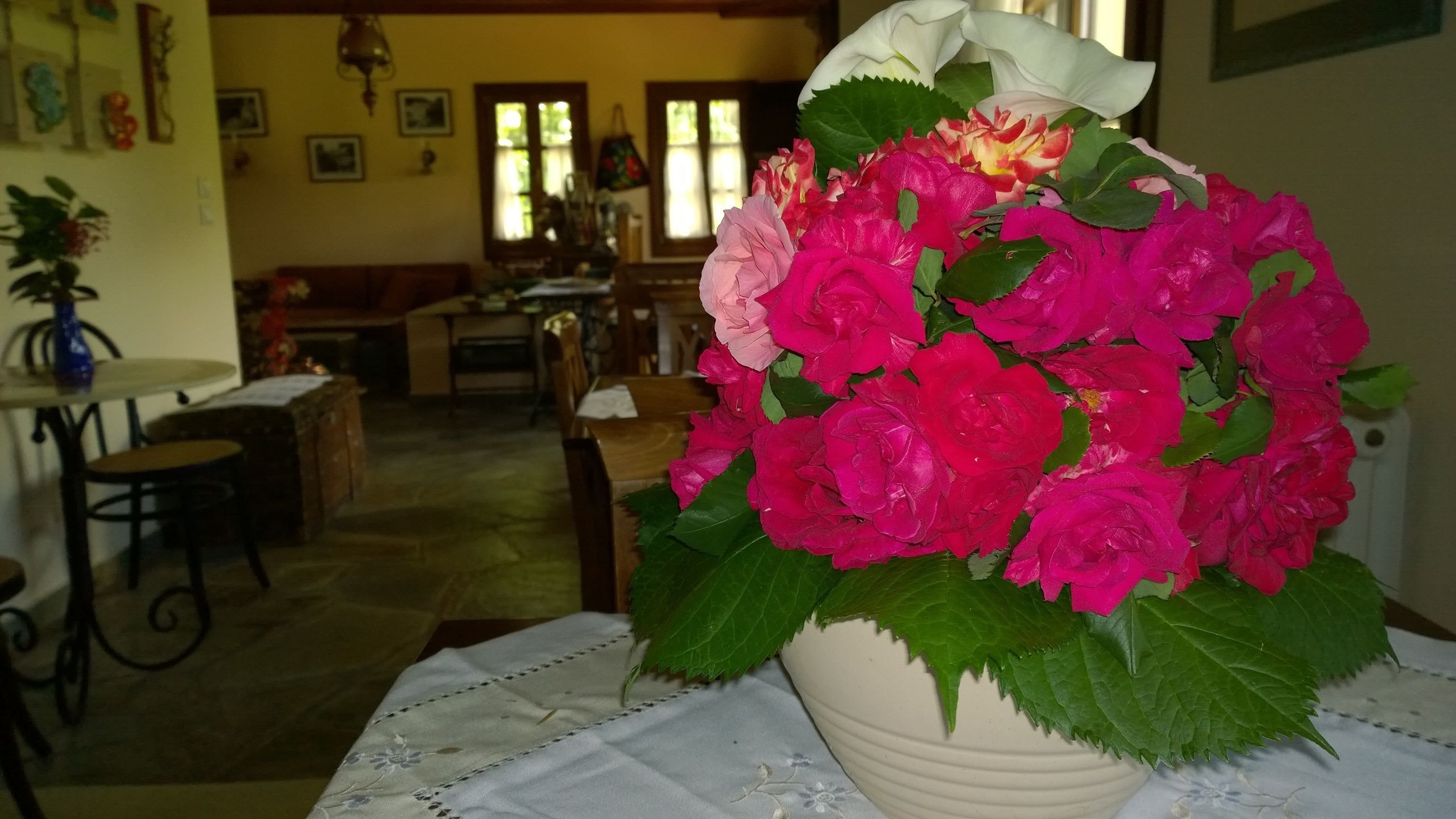 Quarto com uma mesa onde se encontra um vaso de flores.
