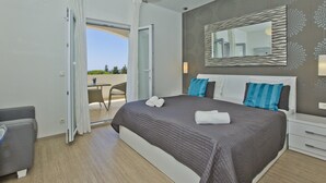 Quarto moderno com cama grande, varanda e vista para o exterior.