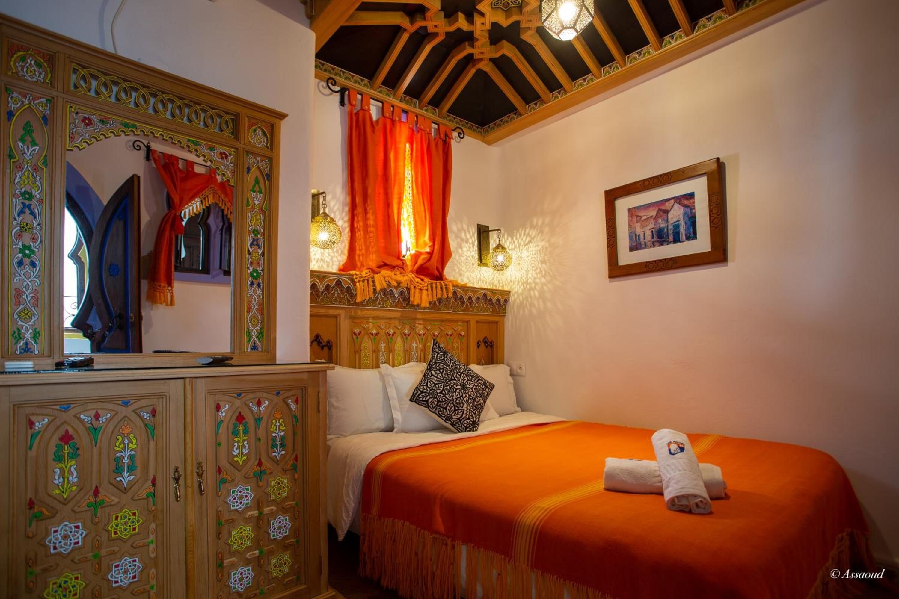 Quarto com cama, espelho e guarda-roupa.