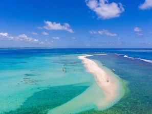 Uma praia com águas turquesa translúcidas e um areal arenoso.