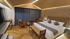 Quarto de hotel com uma cama grande, mobiliário de madeira e um design moderno no teto.