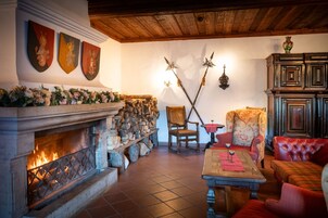 Um quarto acolhedor com lareira de pedra, vigas de madeira e decoração tradicional.