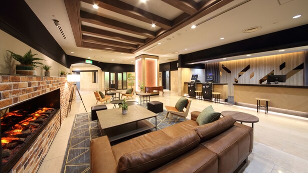 Um lobby moderno com lareira, área de estar e bar.