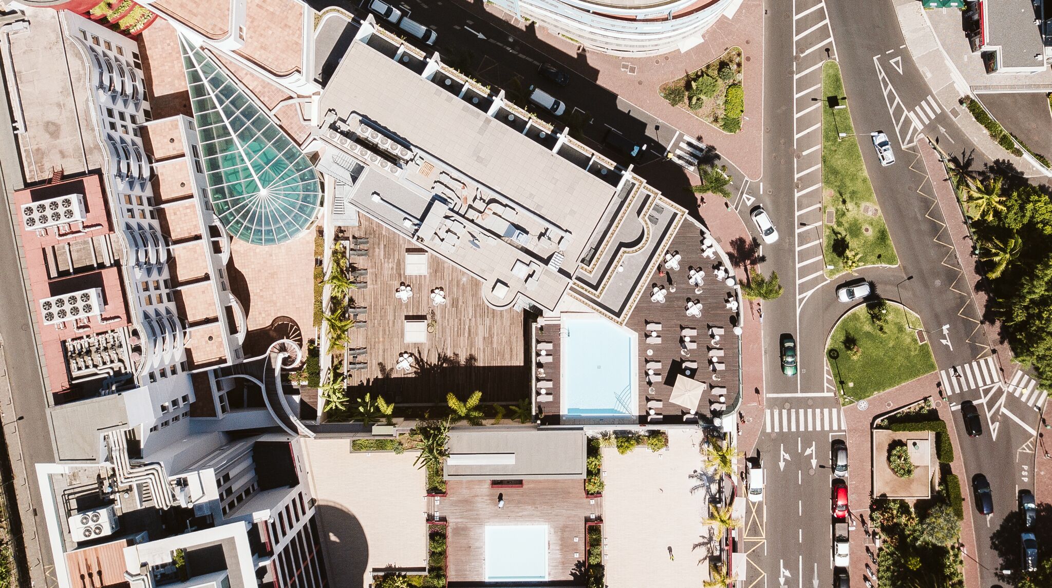 Vista aérea de um hotel com pátio central, área de estar ao ar livre e piscina.