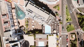 Vista aérea de um hotel com pátio central, área de estar ao ar livre e piscina.