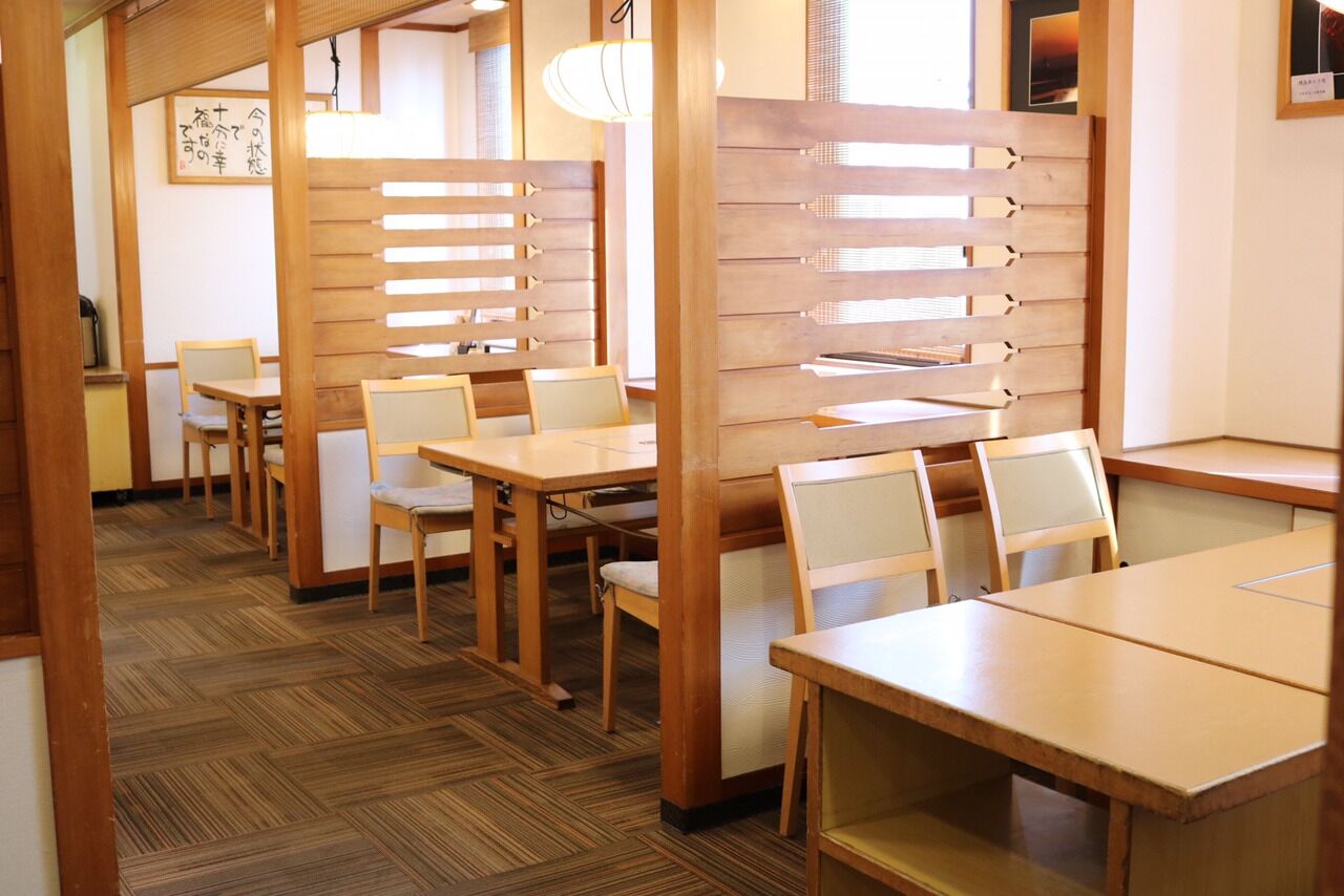Um restaurante com mobiliário de madeira e piso estampado.