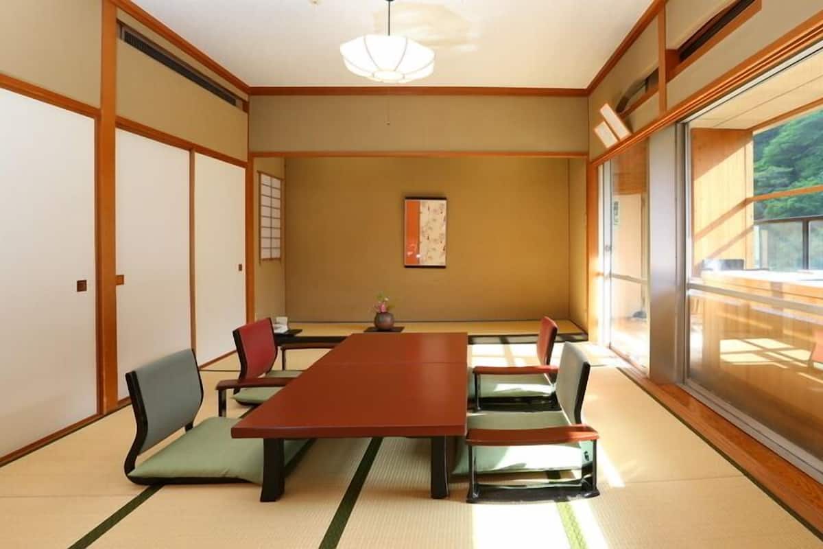 Um quarto em estilo japonês tradicional, com piso de tatame, uma mesa baixa e portas deslizantes.