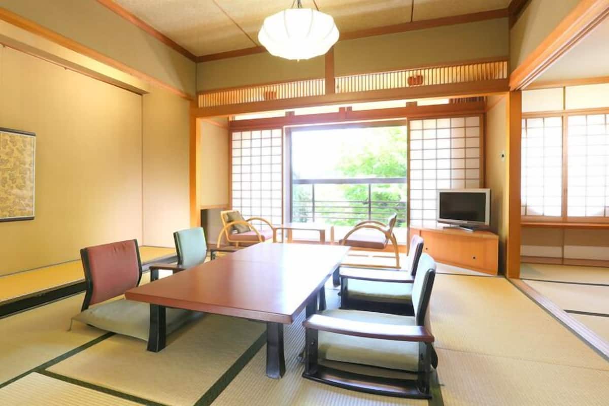 Um quarto japonês tradicional, com tatames, uma mesa baixa e biombos shoji.