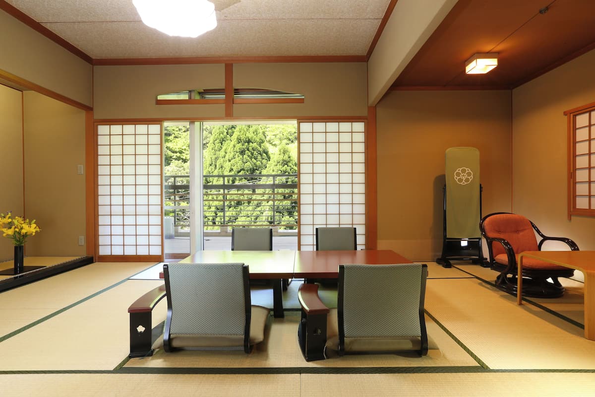 Um quarto japonês tradicional com tatames, uma mesa baixa e assentos.