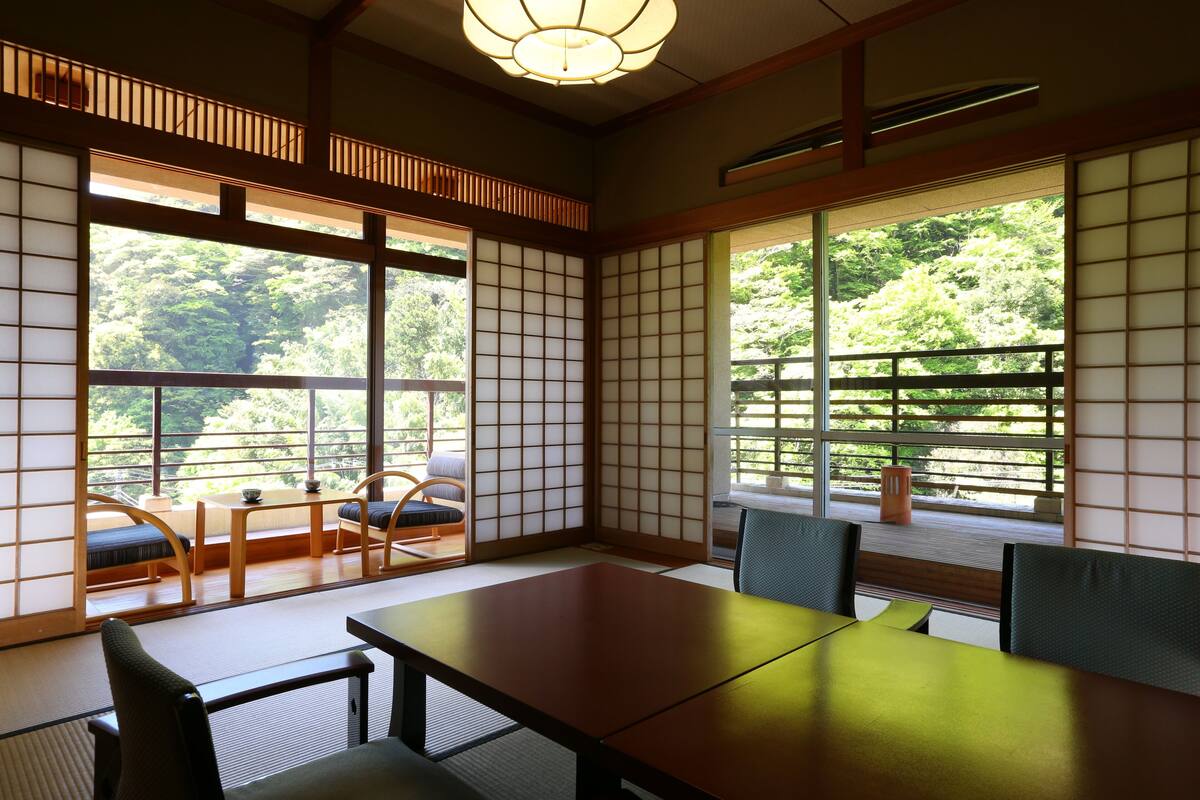 Um quarto japonês tradicional com tatames, uma mesa baixa e portas corrediças.
